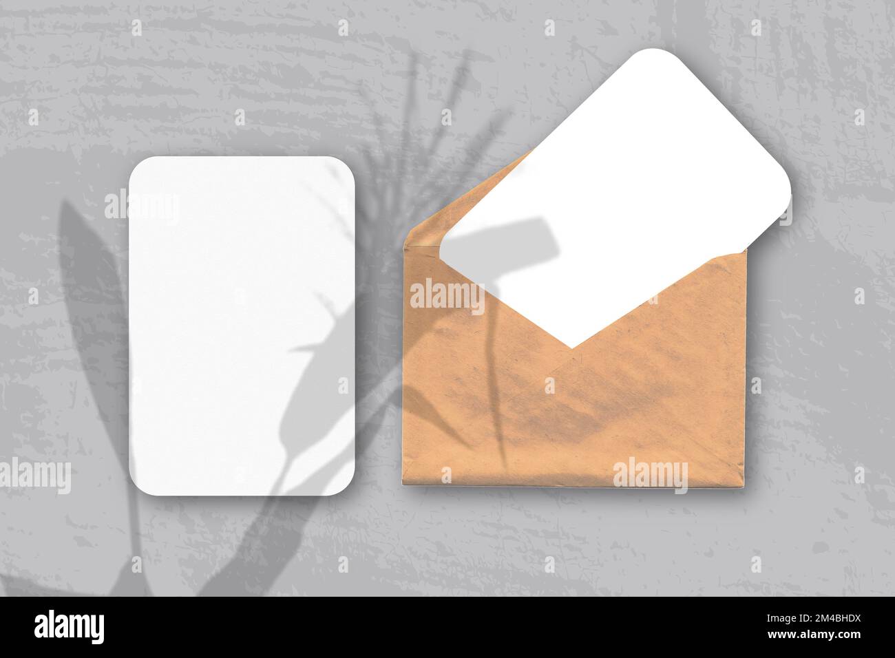 An envelope with two sheets of textured white paper on the gray ...