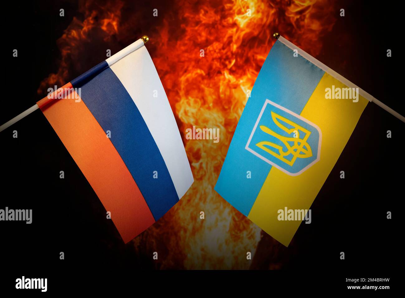 Flags of Russia and Ukraine against the background of a fiery explosion ...