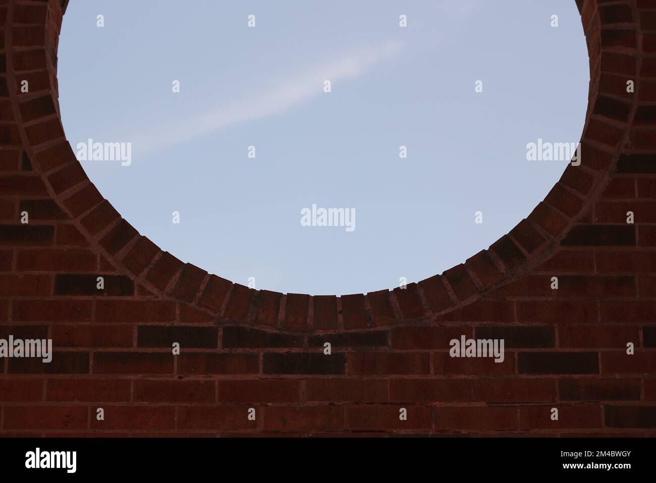 Minimalist brick wall with a circular oval opening Stock Photo - Alamy
