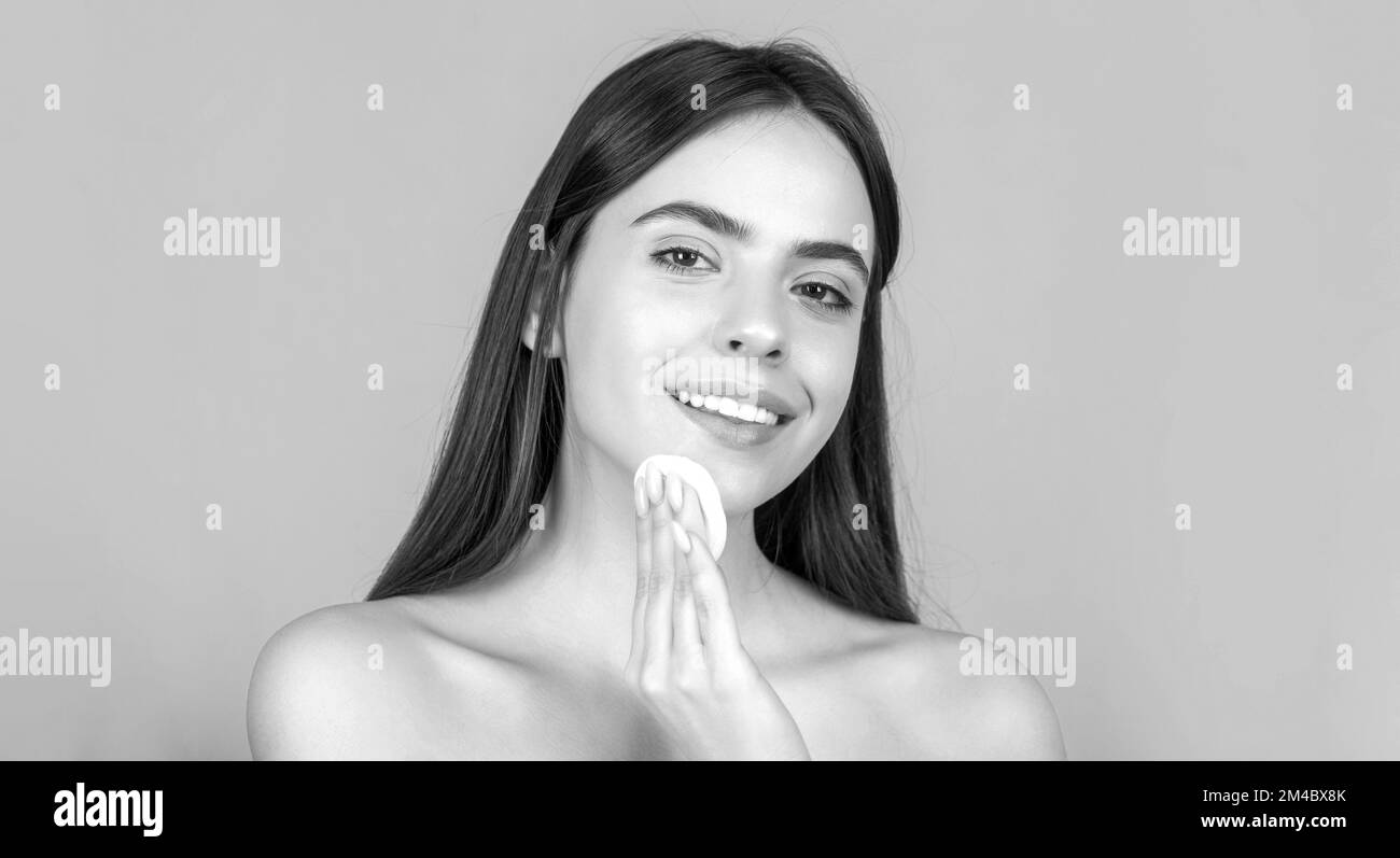 Beautiful brunette woman with clean perfect fresh skin using cotton pad skin care concept. Black ...