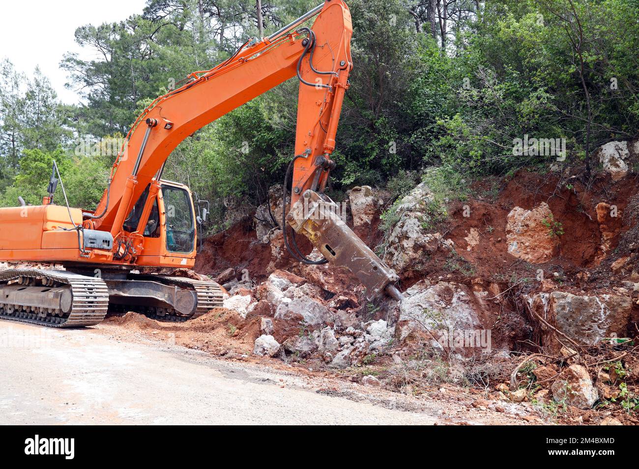 excavator crusher machine breaks rocks to widen road Stock Photo - Alamy