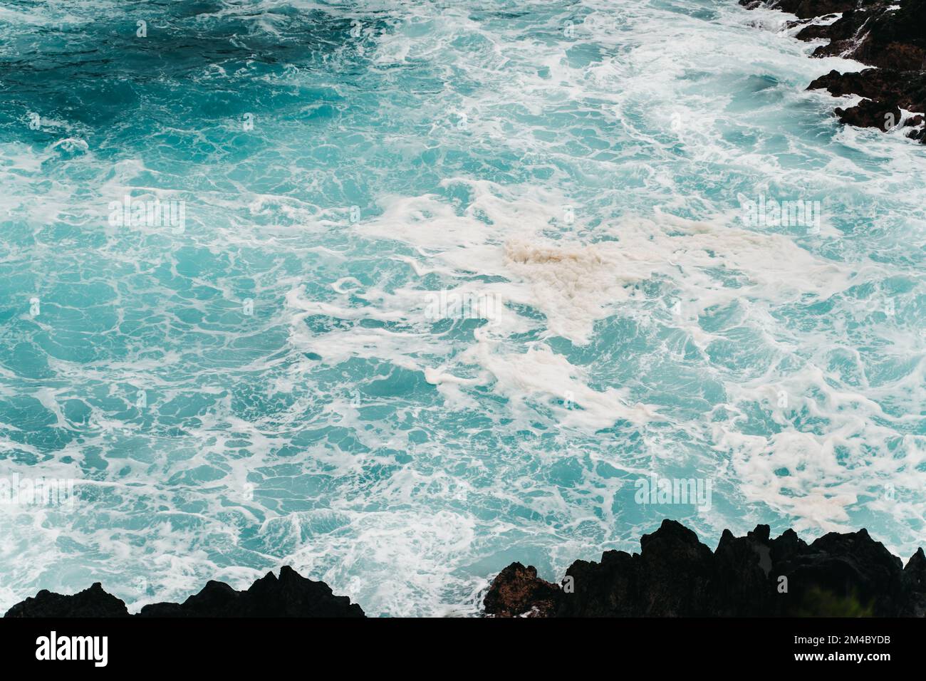 a large body of water surrounded by rocks Stock Photo - Alamy