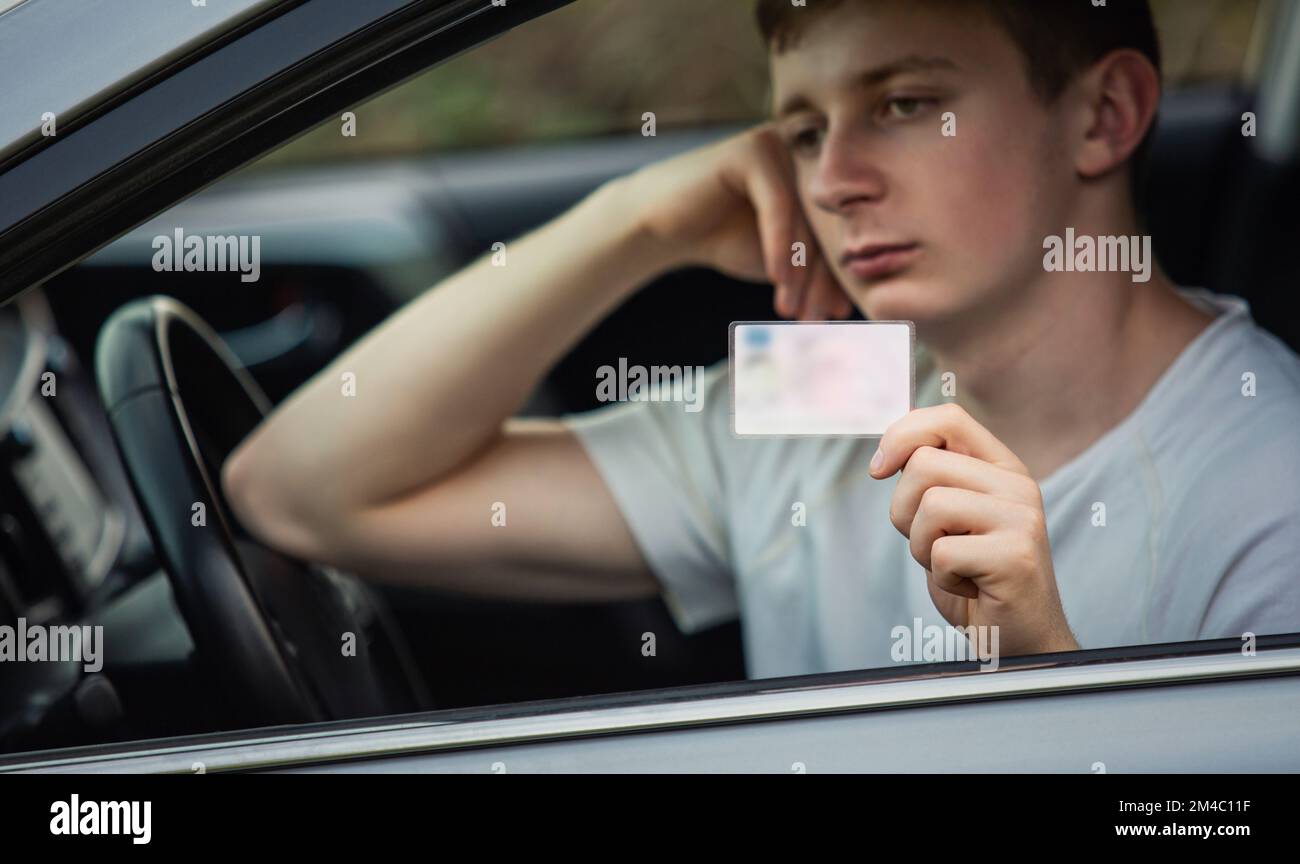 Upset driver showing his driver license out of the car window as for ...