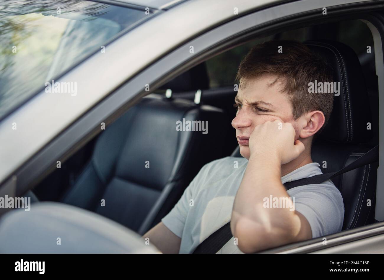 Upset and dissatisfied driver looking sullenly at the traffic jam ahead ...