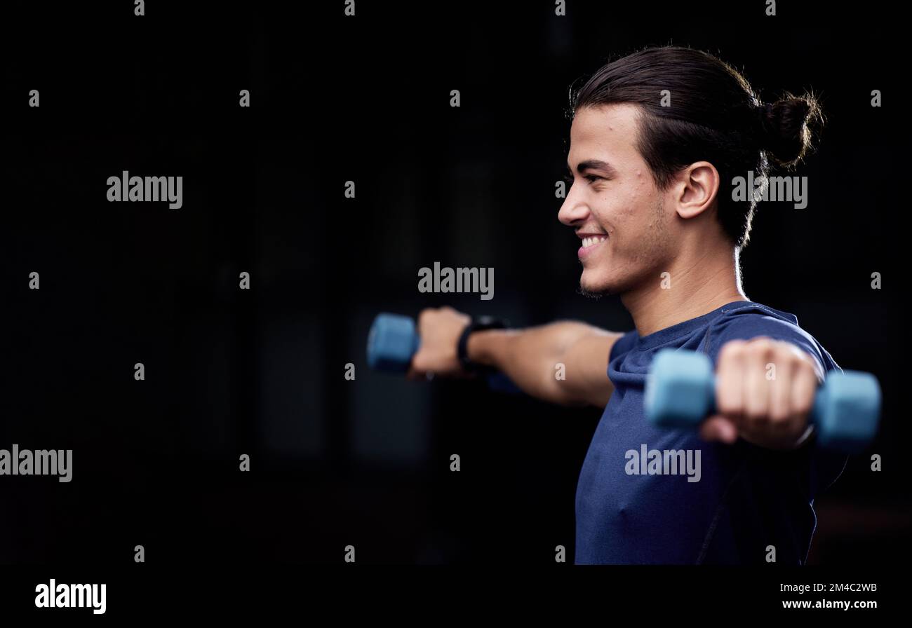 Man, fitness and dumbbells with smile by black background for health ...