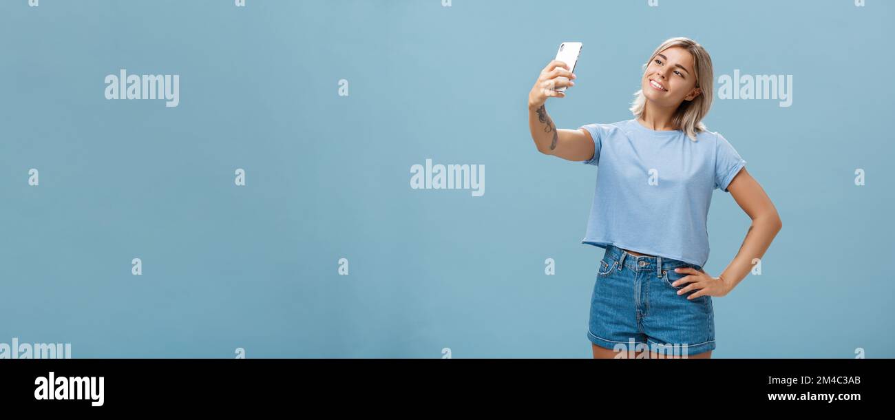 Stylish cute female gym manager taking selfie with new smartphone ...