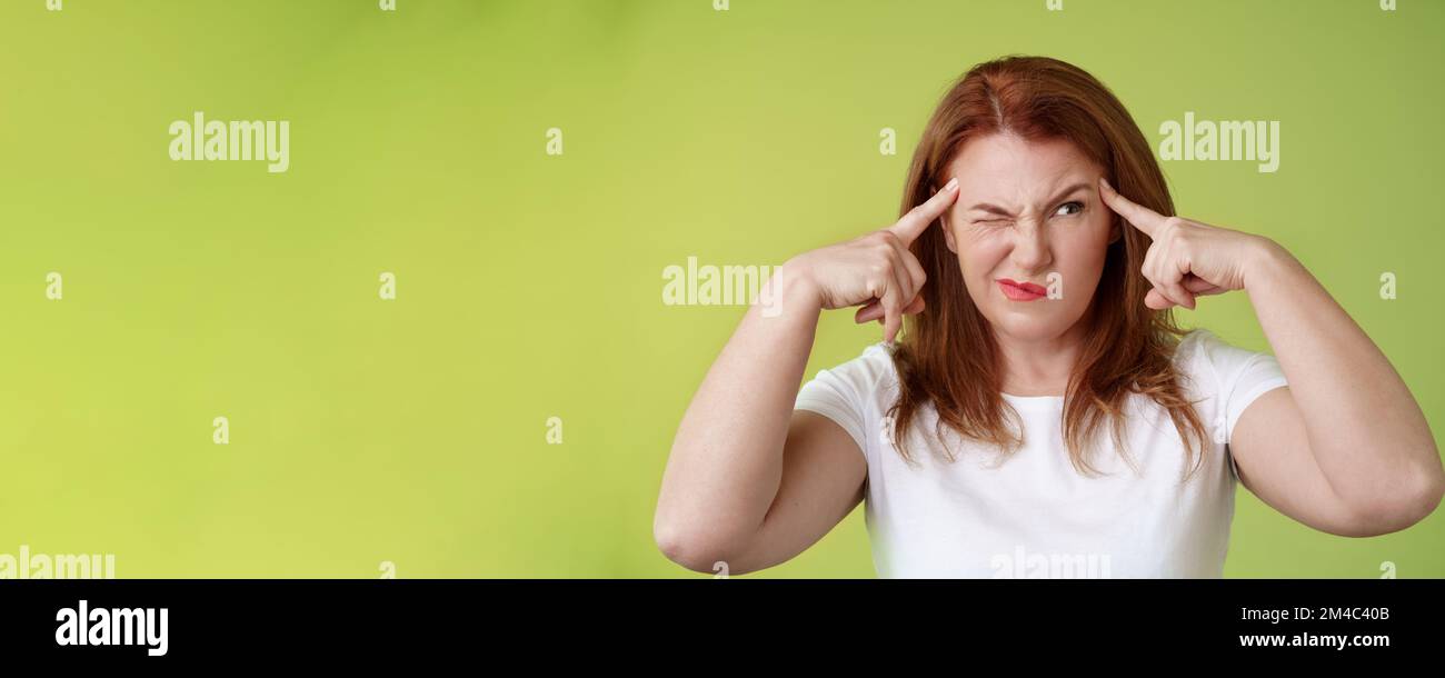 Difficult decision. Perplexed hesitant redhead middle-aged 50s woman ...