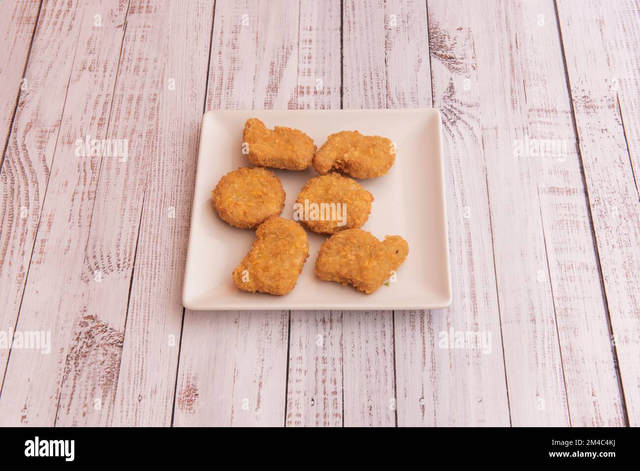 A tray of fried chicken nuggets on a white table Stock Photo - Alamy