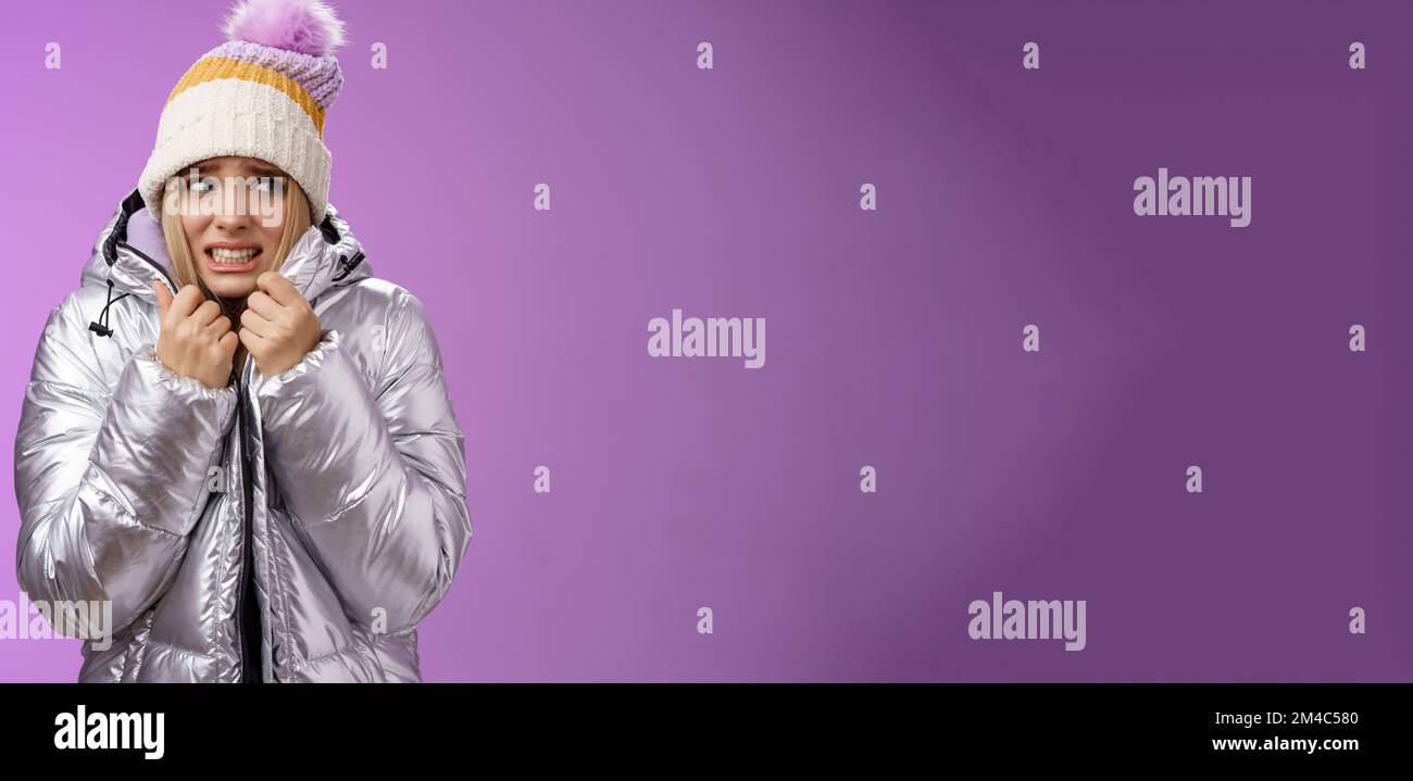 Freezing uncomfortable trembling cute blond girl in hat pull jacket ...
