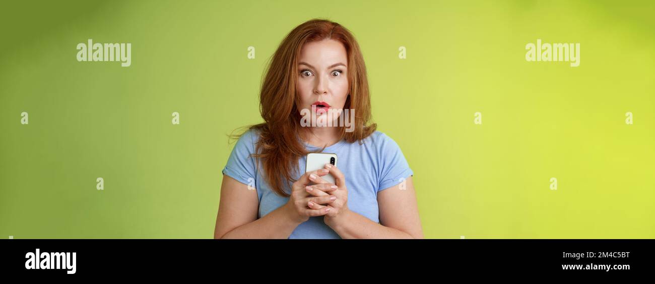 Shocked speechless impressed redhead european middle-aged woman fold ...