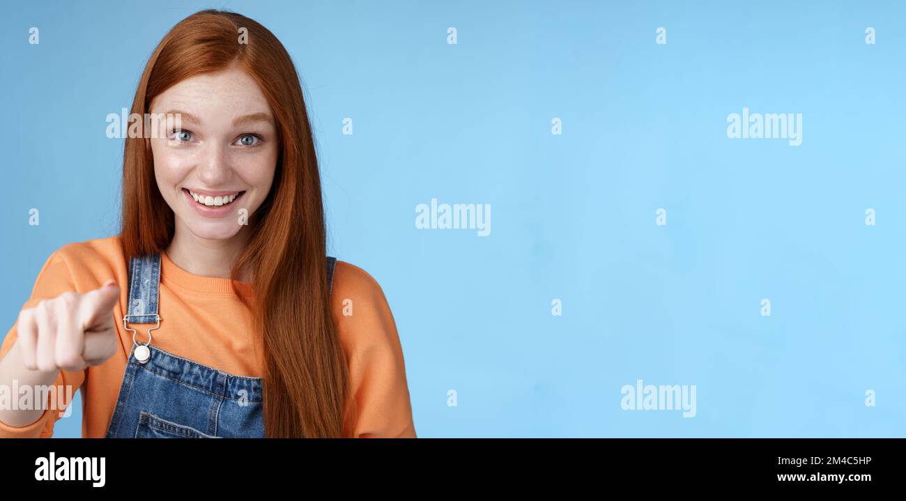 Impressed surprised young cute girl pointing camera amazed wide eyes ...