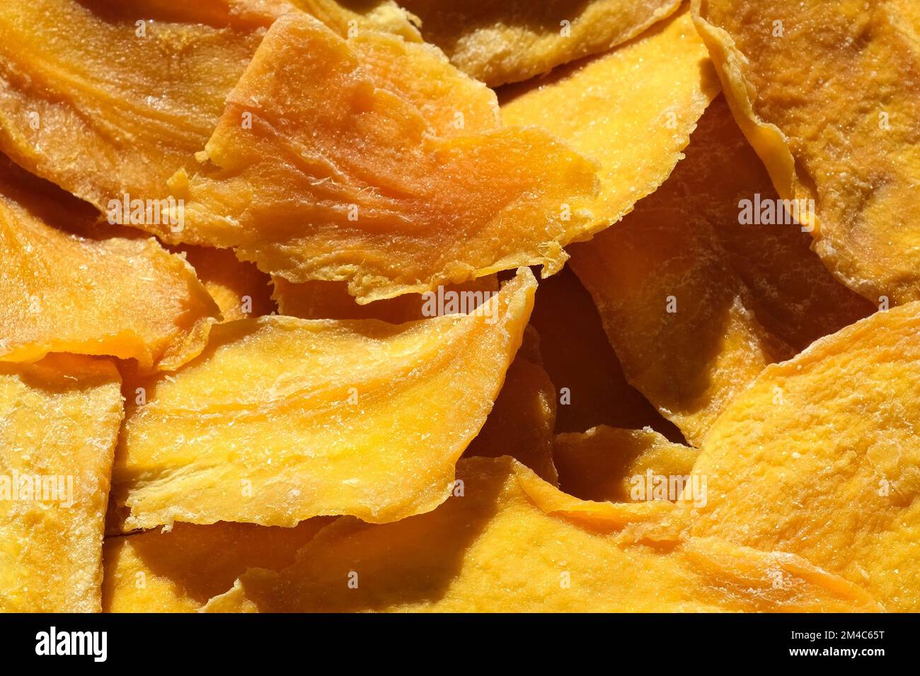 Dried mango slices close-up on a white. Top view. Closeup. Mango chips ...