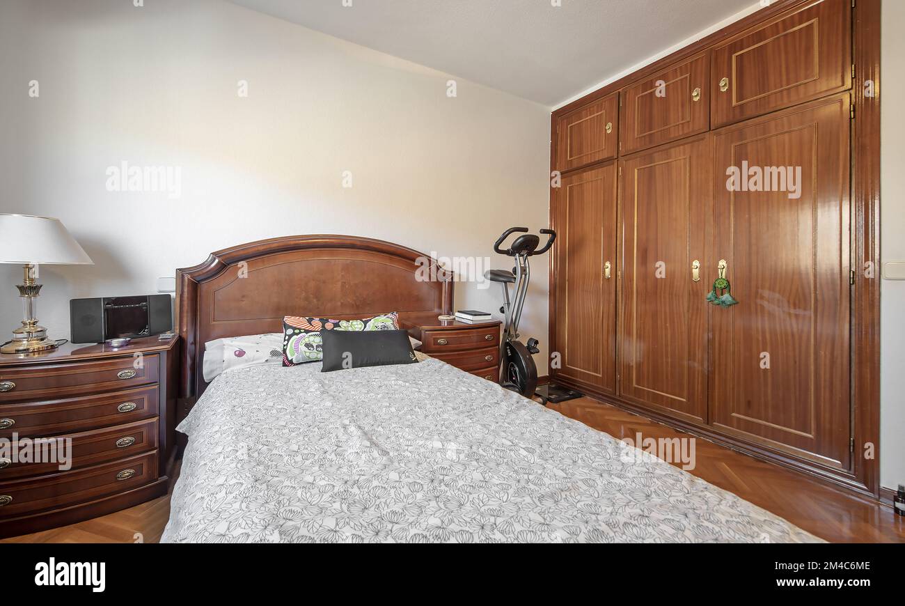 Bedroom with a wooden bed combined with furniture and a wardrobe in an ...