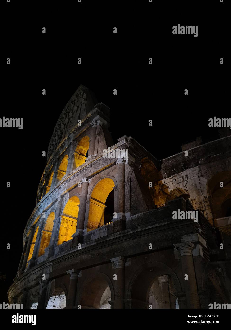 A vertical low angle shot of the Colosseum on the background of the ...