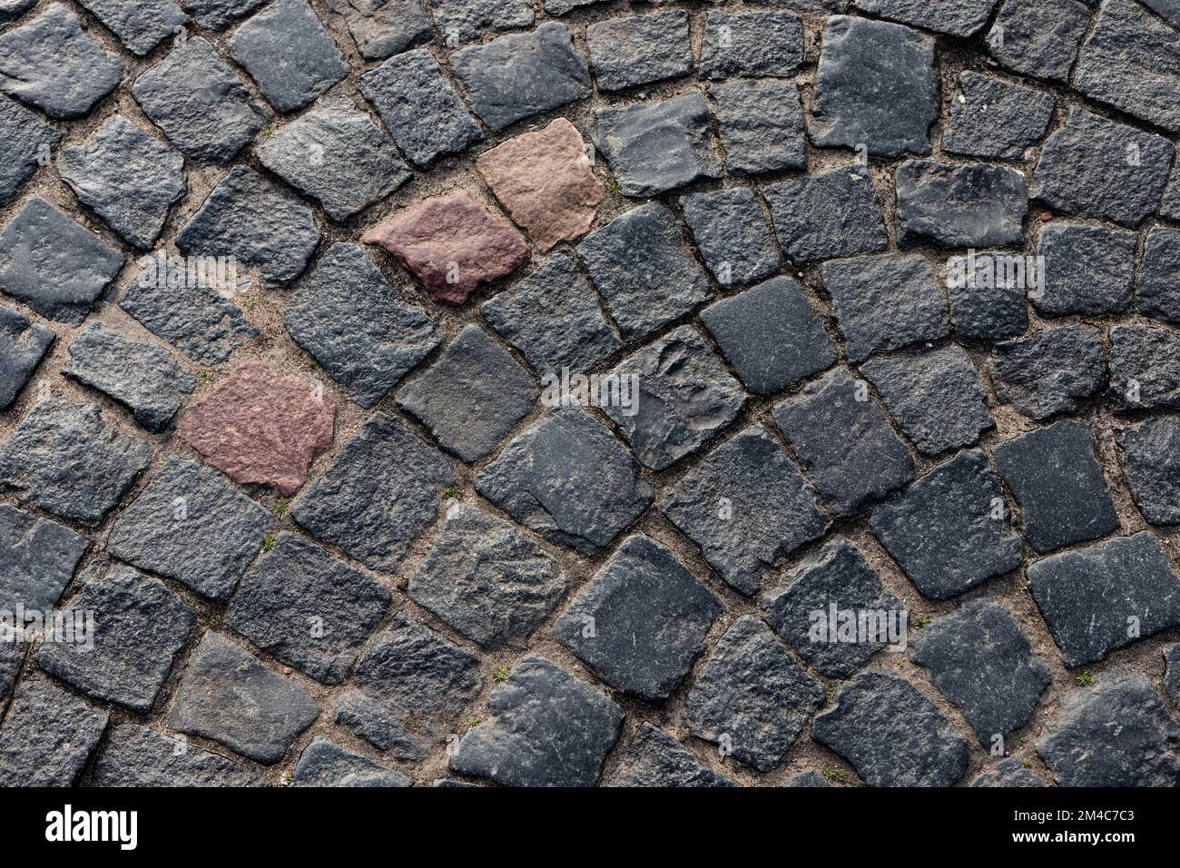 Black cobblestone street pavement with red bocks, top view, urban ...