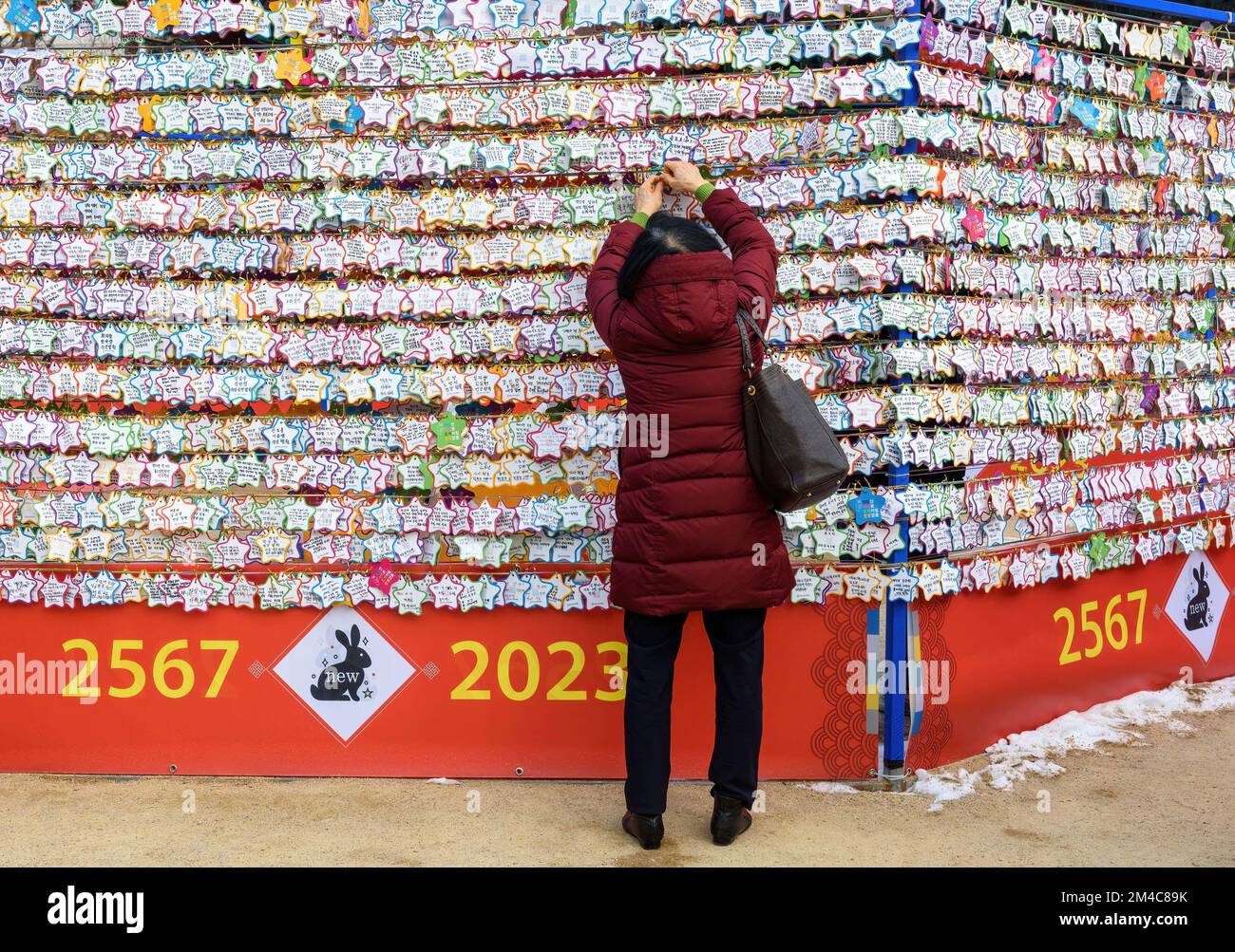 A visitor attaches a New Year's wish note to the 2023 New Year's Wish ...