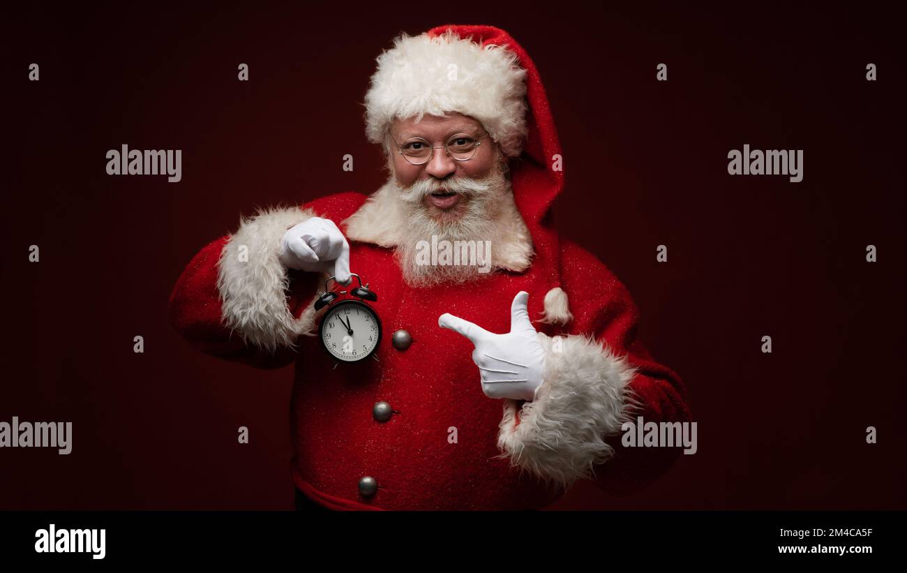Santa claus pointing at alarm clock almost midnight Stock Photo - Alamy