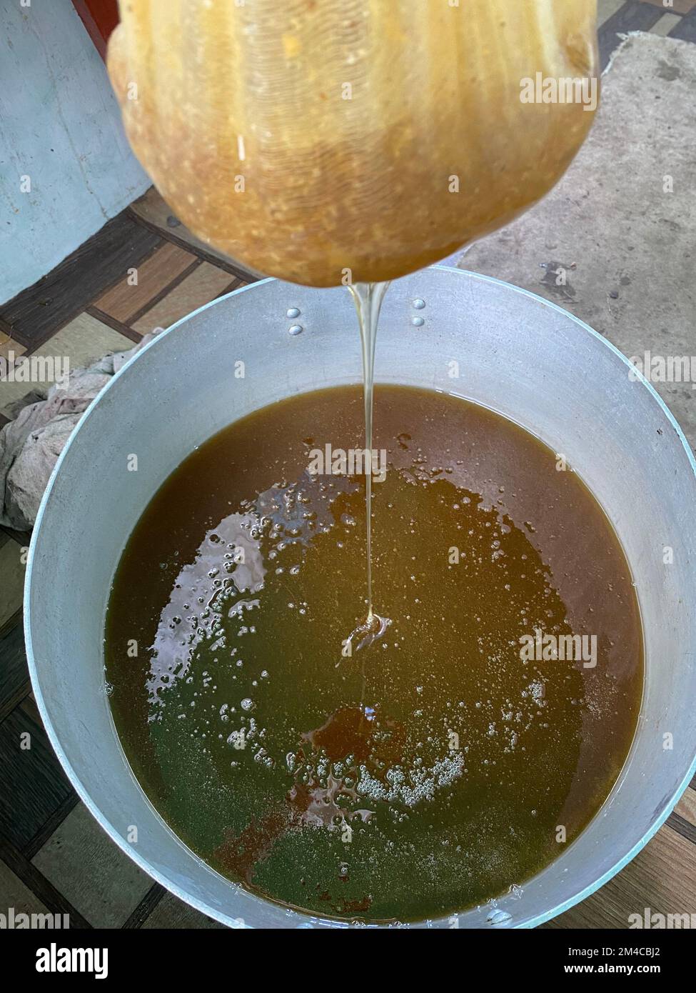 honey is poured into a pot. honey in a large cistern. High quality ...