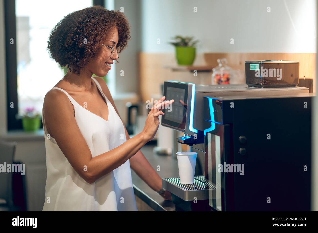 Company employee making herself a beverage in the office kitchen Stock ...
