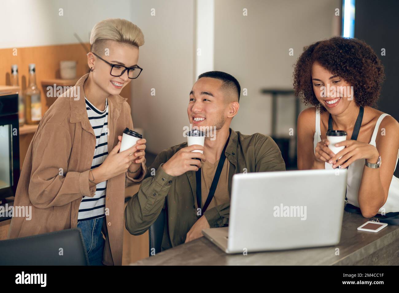 Corporate workers enjoying their coffee break in the office kitchen ...