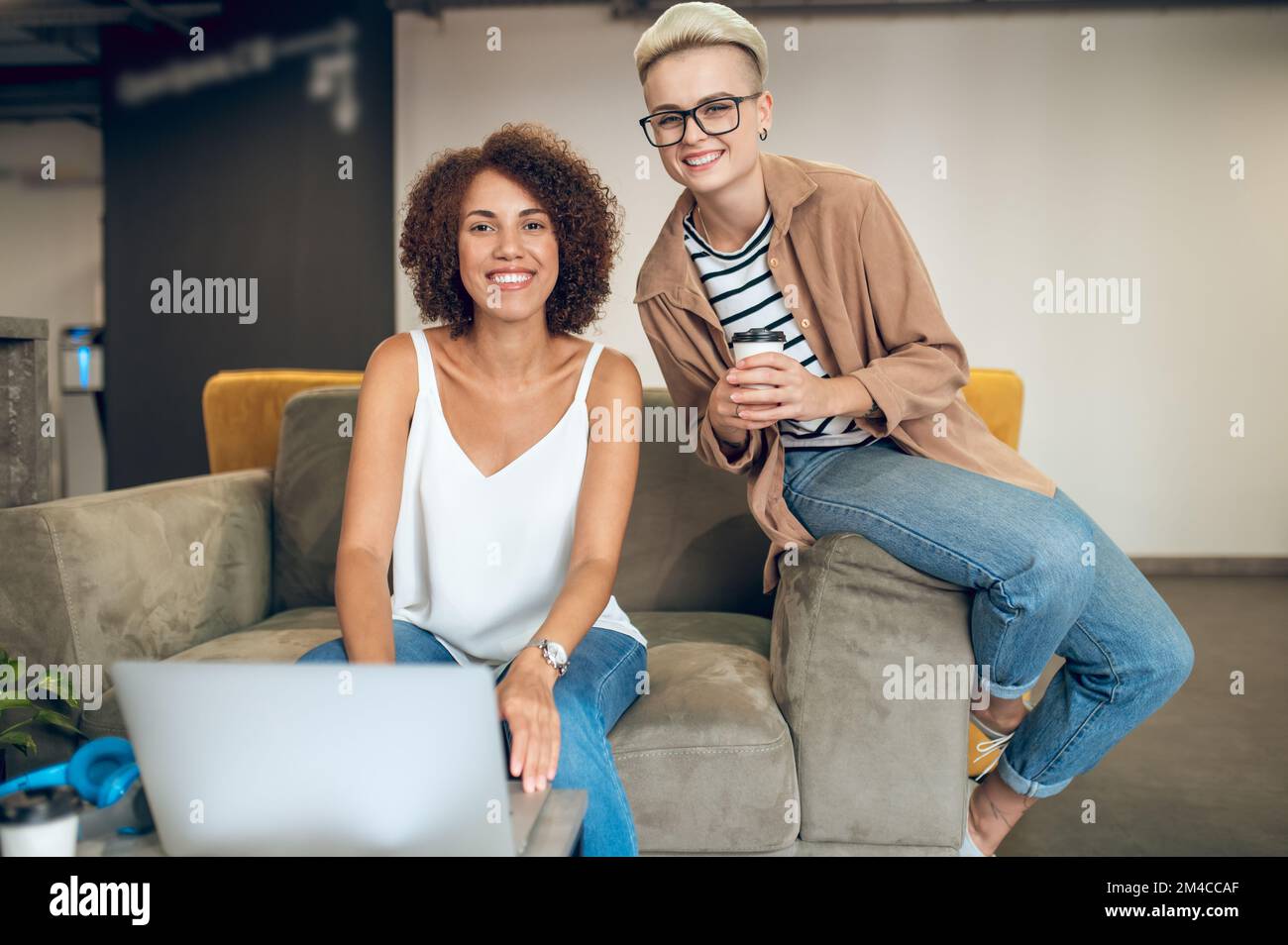 Joyful company workers posing for the camera at work Stock Photo - Alamy