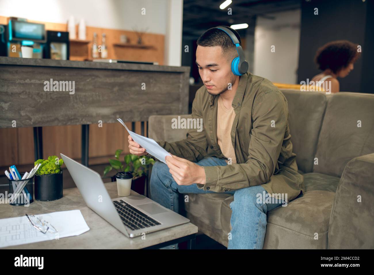 Concentrated young Asian office worker perusing business documentation ...