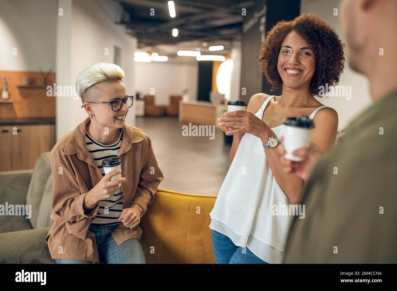 Two female office workers enjoying the communication with their ...