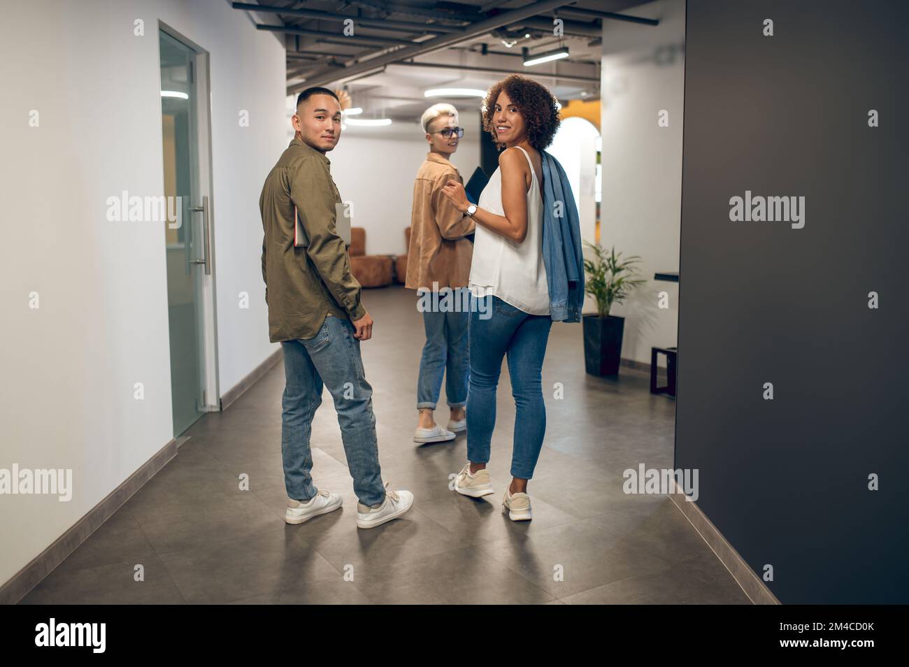 Young multinational team of corporate workers in the office corridor ...