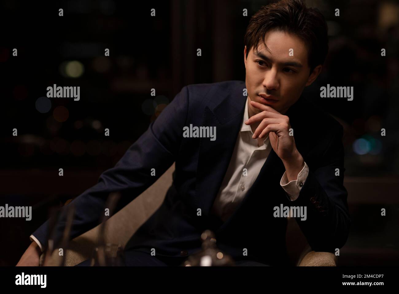 Elegant young Chinese man thinking Stock Photo - Alamy