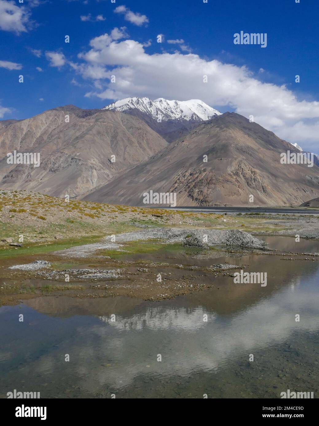 View of Hindu Kush snow-capped peak with reflection in water on Afghan ...