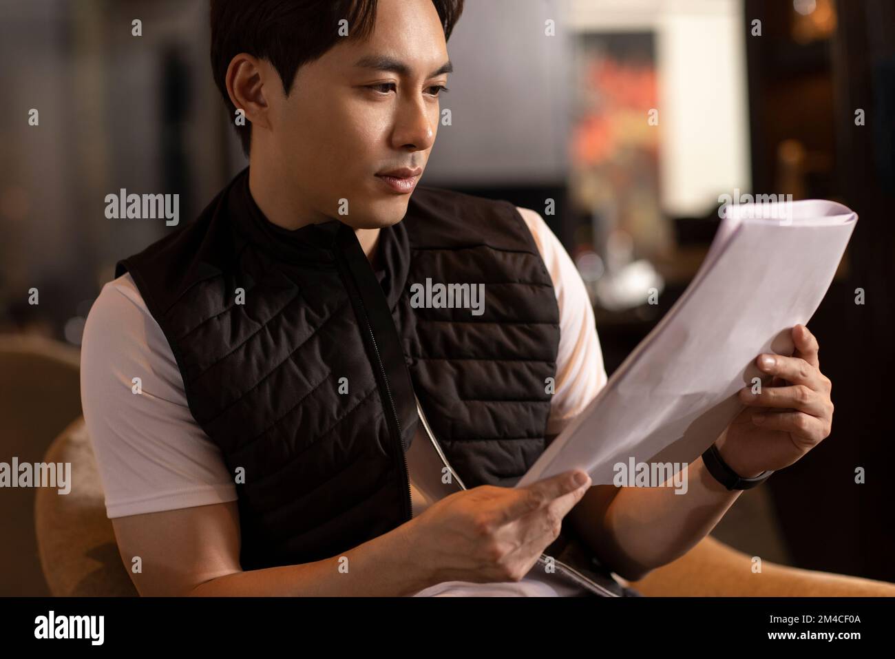 Chinese mid adult man reading files Stock Photo - Alamy