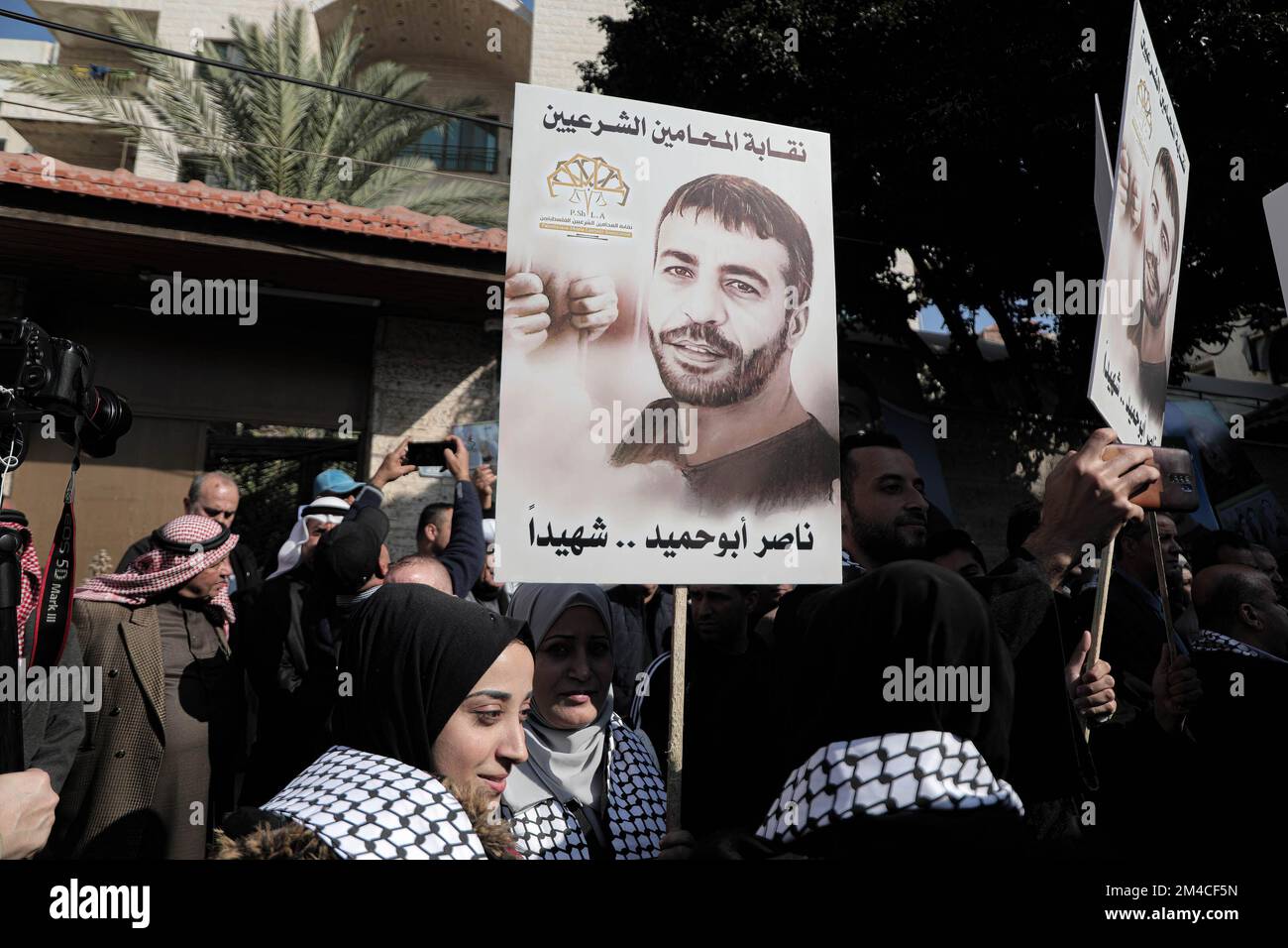 Gaza, Palestine. 20th Dec, 2022. Protesters hold posters with pictures ...