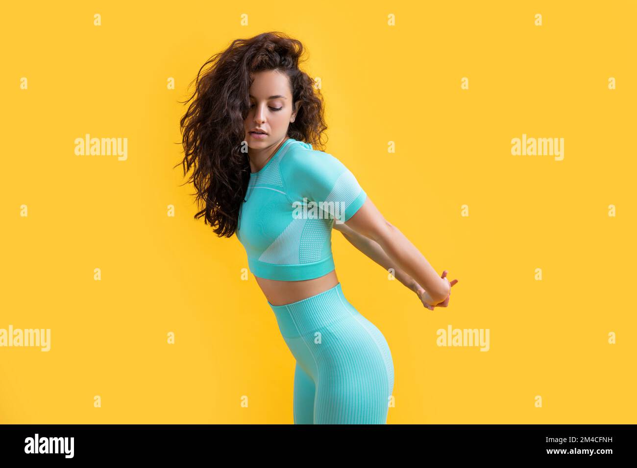 Athletic woman stretching arms back with hands clasped studio. Fit ...