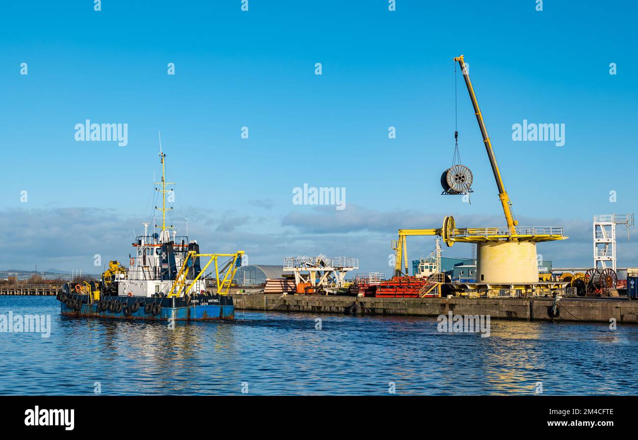 Forth Sentinel utility ship dredging Leith Harbour with crane lifting ...