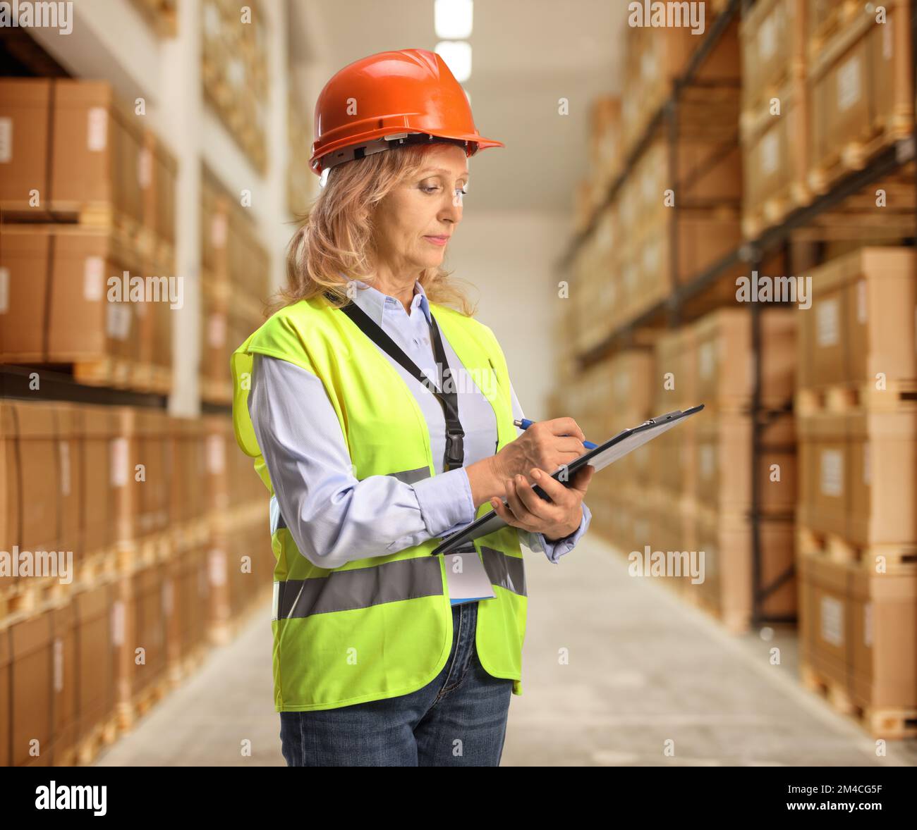 Female engineer with a safety vest and helmet writing a document inside ...