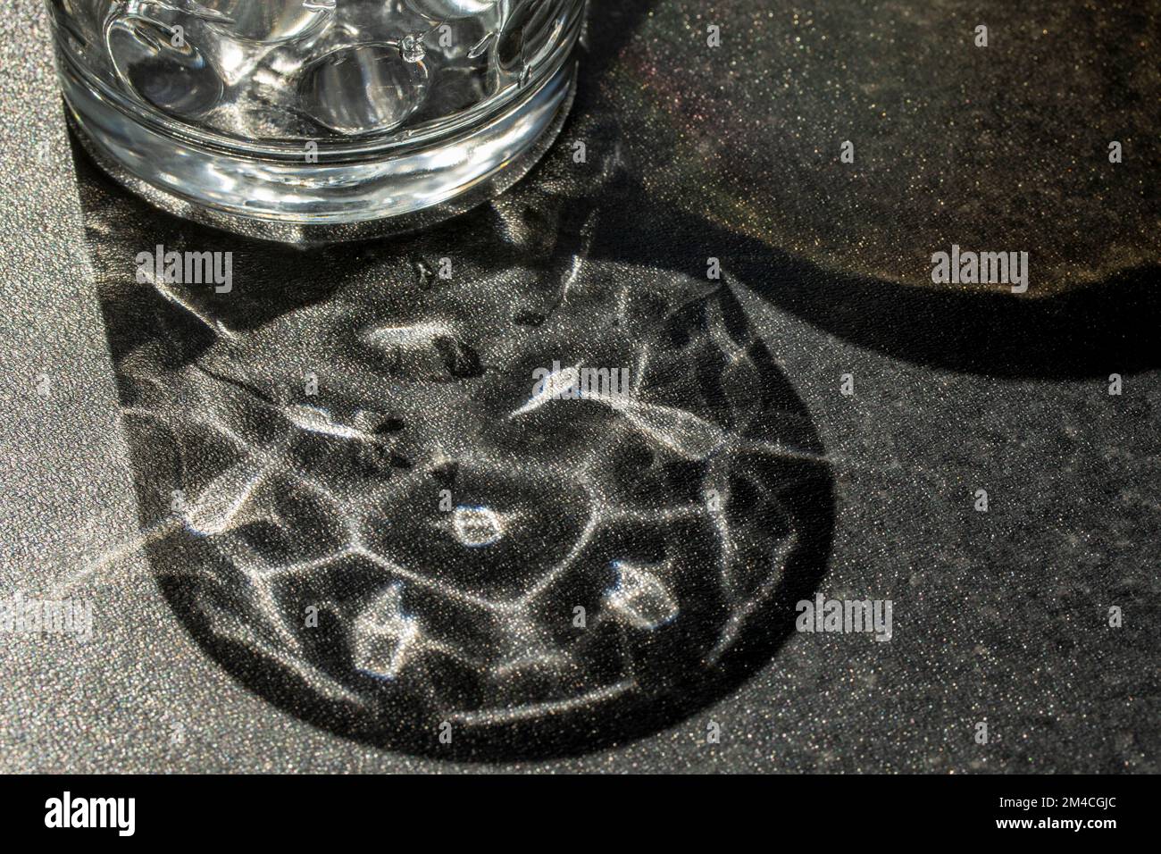 Natural close up still-life patterns formed by crystal glass on a work ...