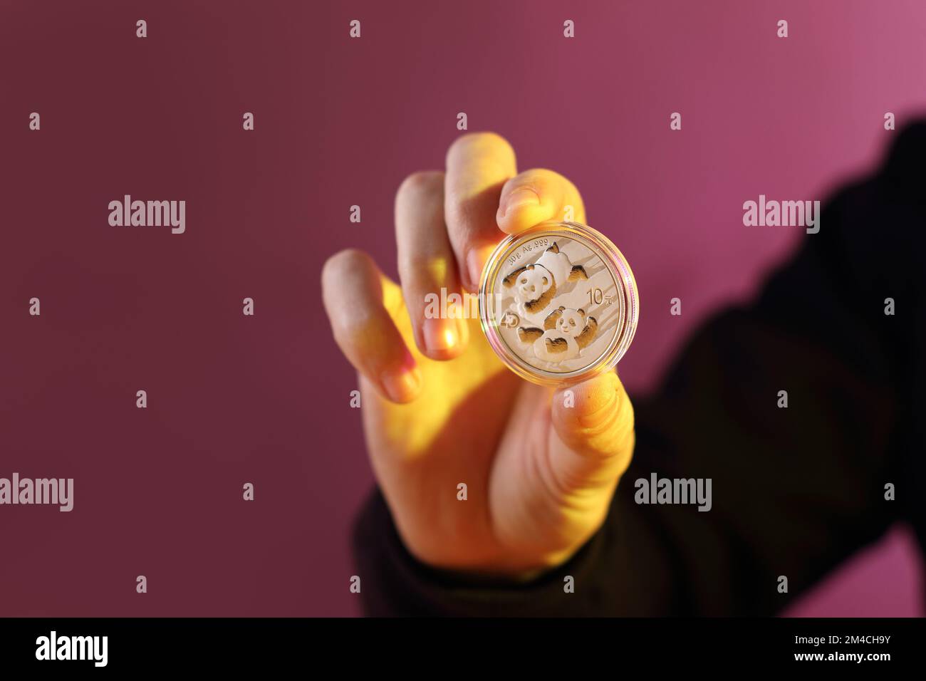 10 yuan silver coin in fingers above the table face forward Stock Photo ...