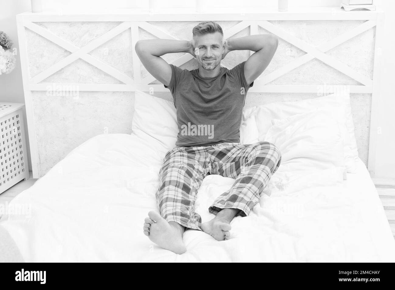 Wake up and smile. Happy man in pajamas relax in bed. Waking up in ...