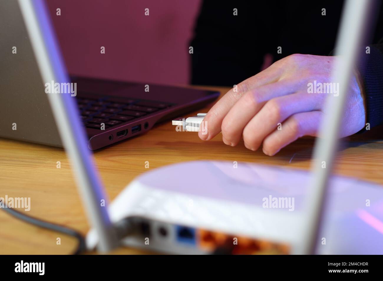 inserting a gsm modem into a laptop by a person in a black sweatshirt ...