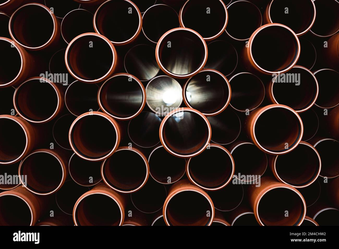 A horizontal shot of lots of orange cylinders on a black background ...