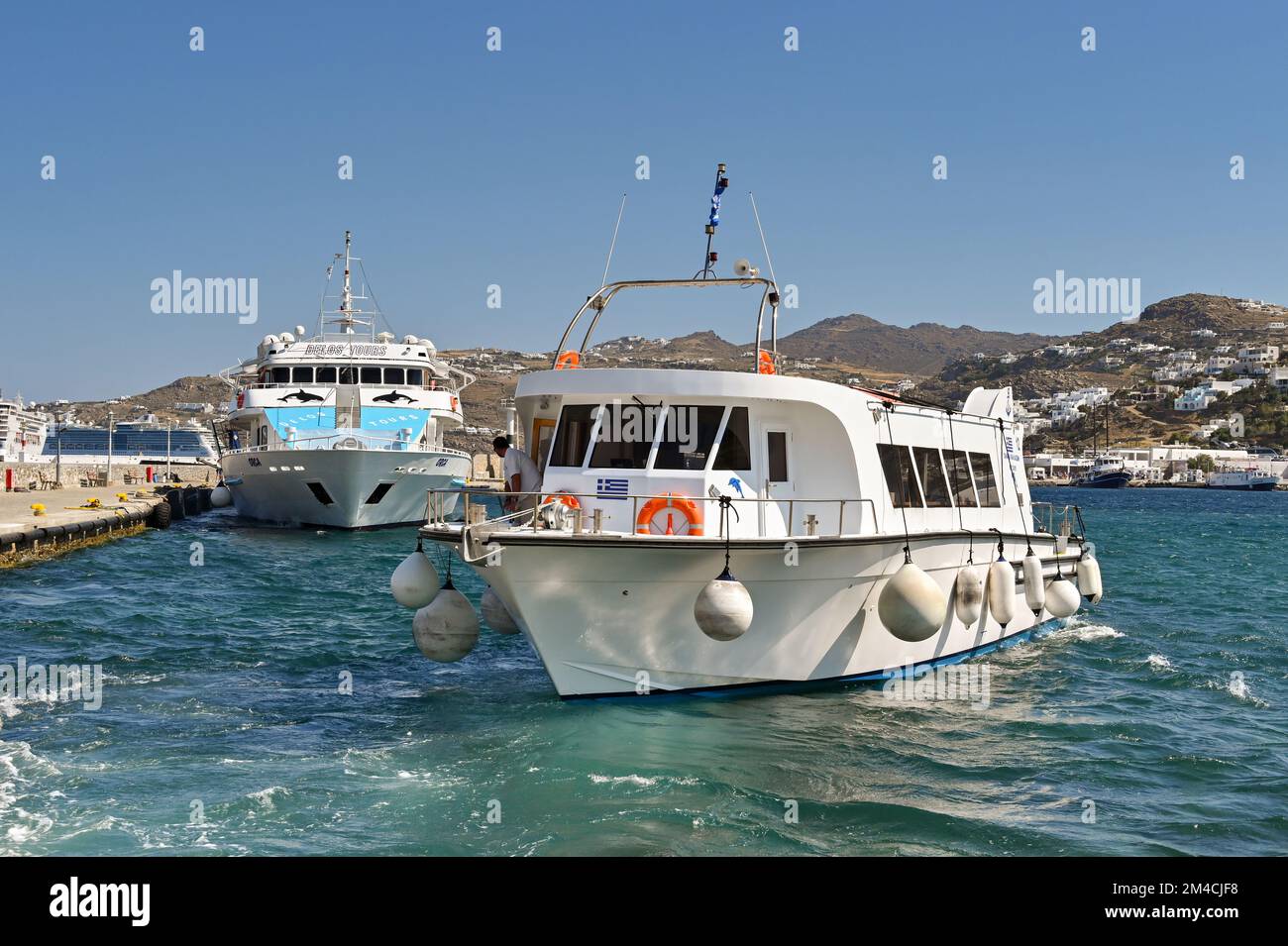 Mykonos, Greece - June 2022: Small ferry boat arriving in the town's ...