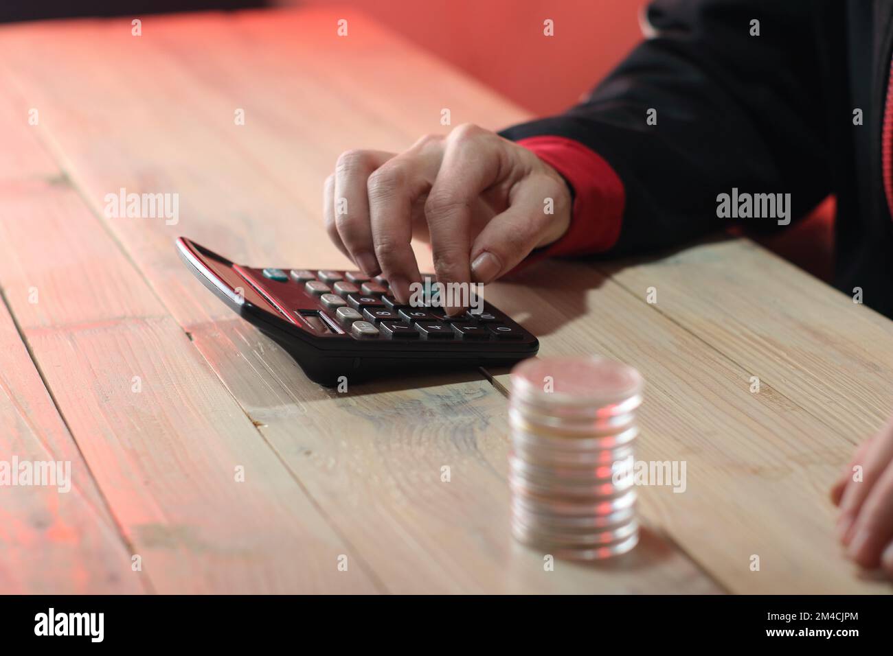 counting with a calculator next to coins in clips on the table and ...