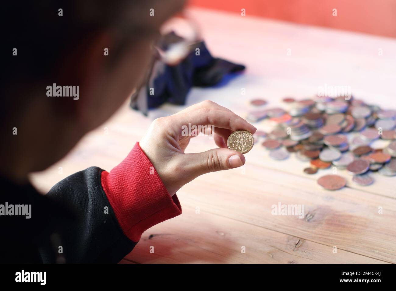 us dollar coin in the fingers on the background of the table with coins ...