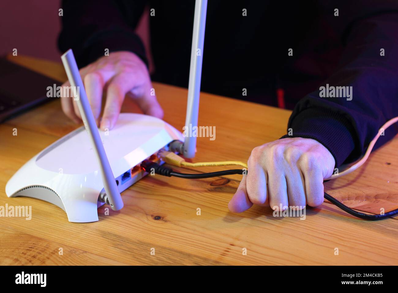 pulling out the internet cable from the router on the table and on the ...