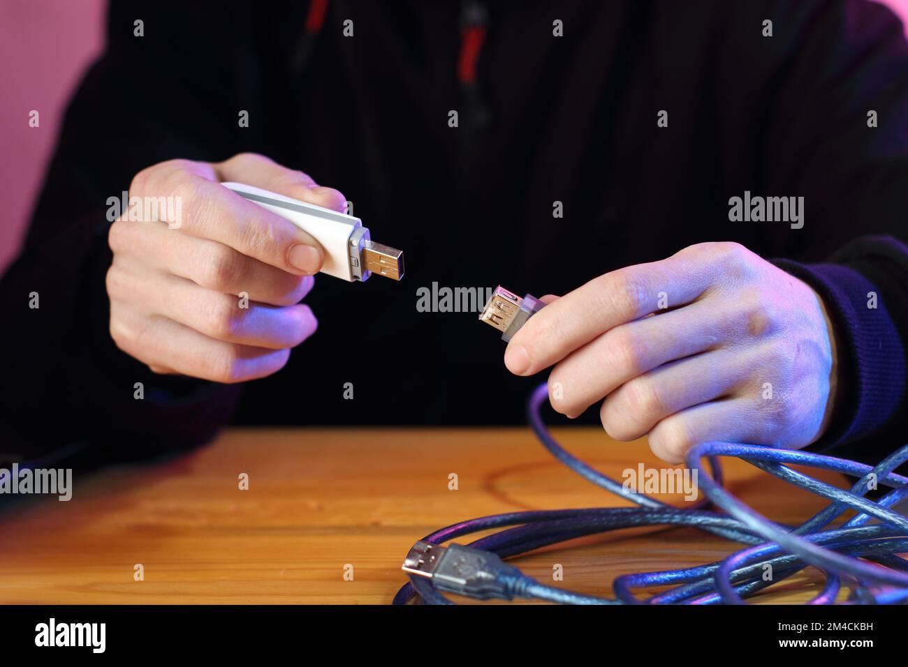 connecting a card modem to a blue usb cable by a person in a black ...