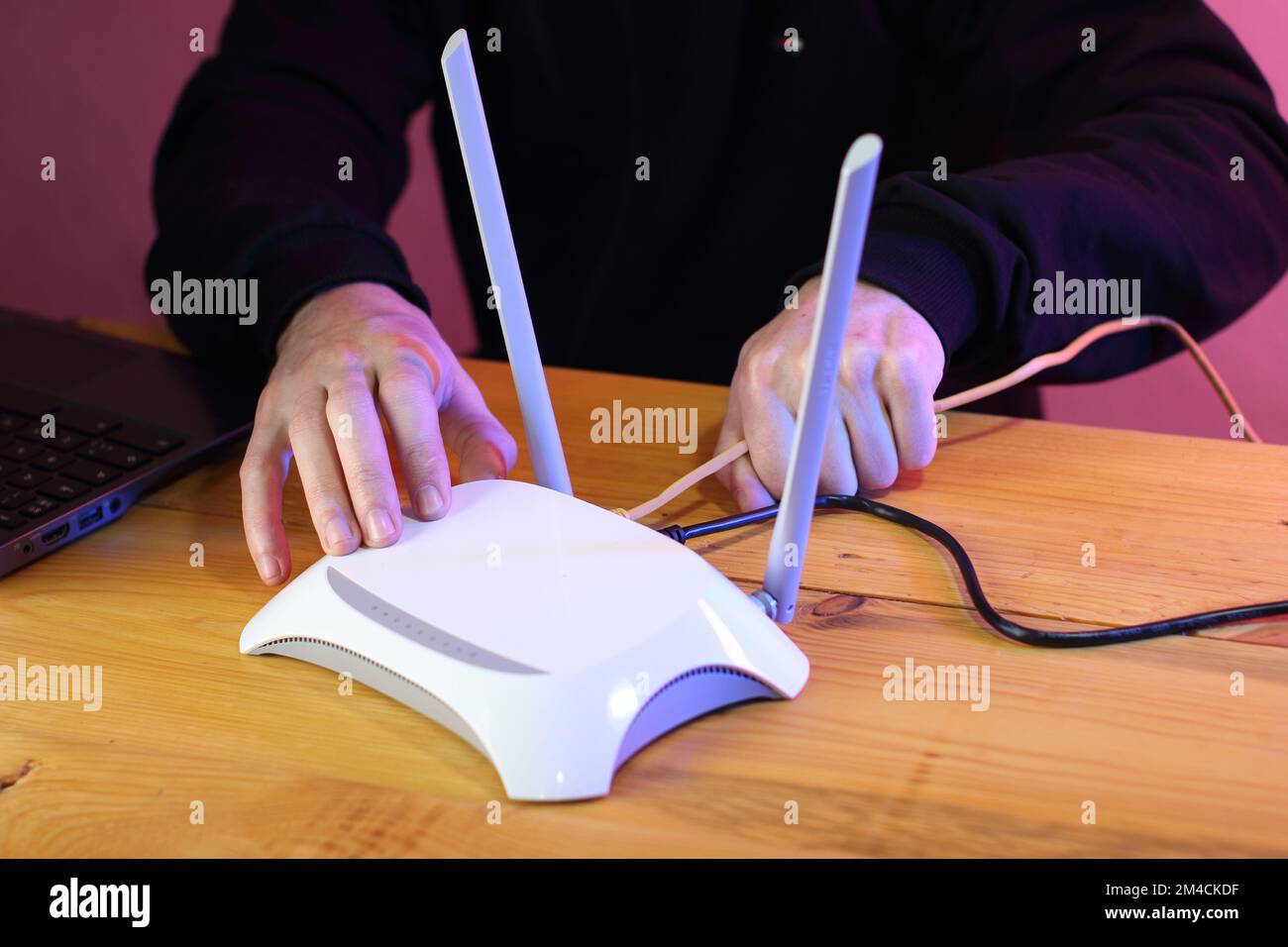 pulling out ethernet cables from a white router with antennas by a ...