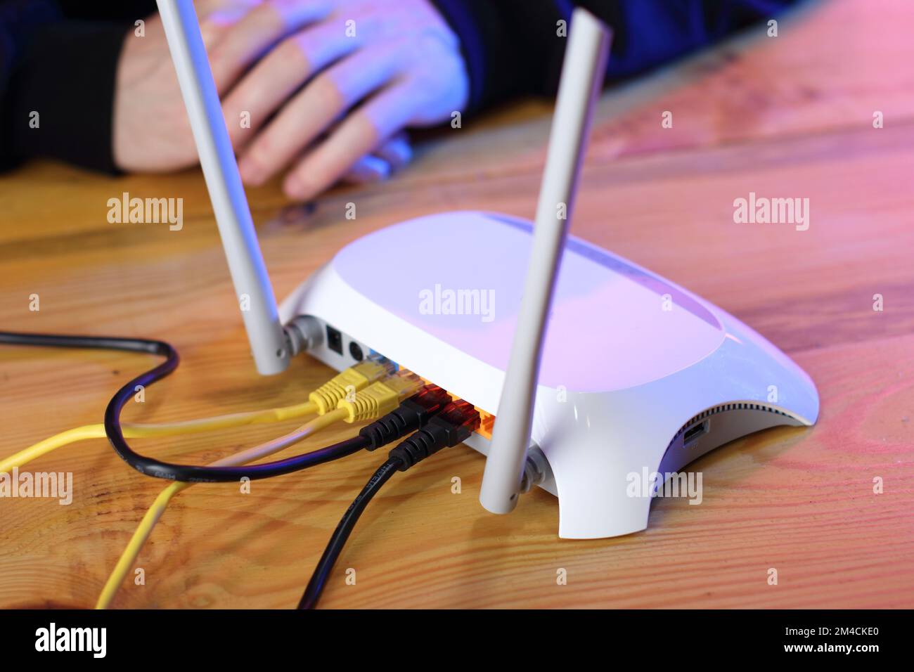 router with connected ethernet cables on table and person's hands Stock ...