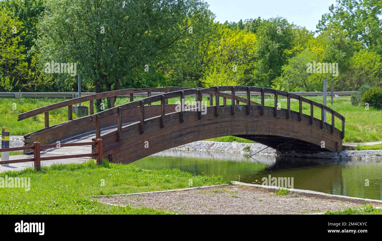 Wooden Arch Bridge Over Pond for Pedestrians in Park Stock Photo - Alamy