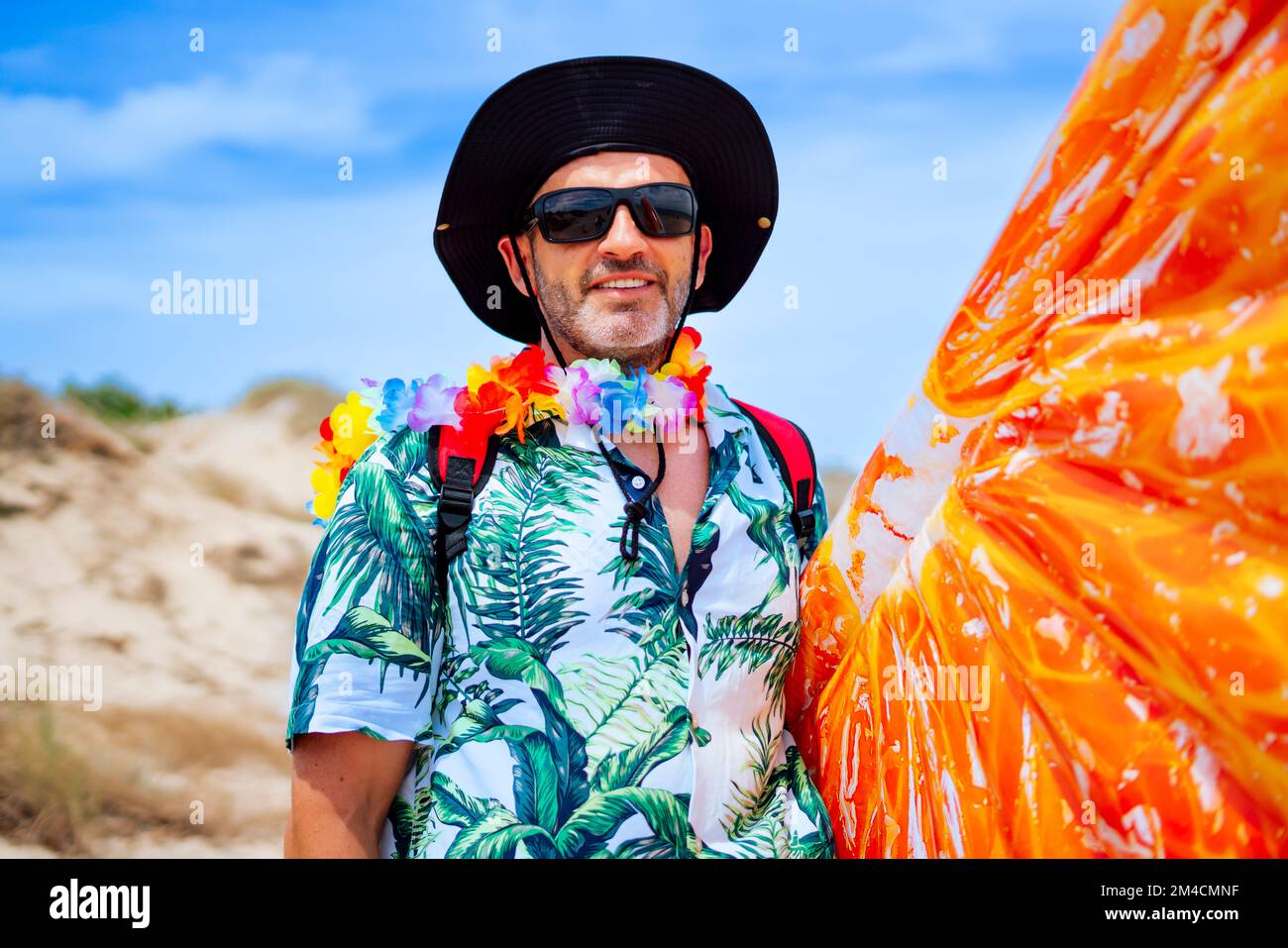 Bald man playing and enjoying his float and mobile, on the beach Stock ...