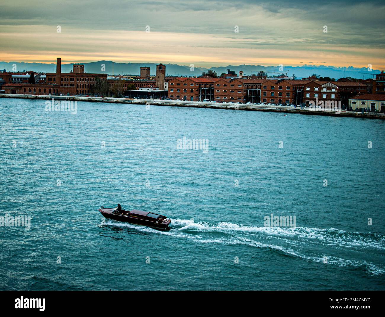 A bird's eye view of a boat driving in a lake with residential ...